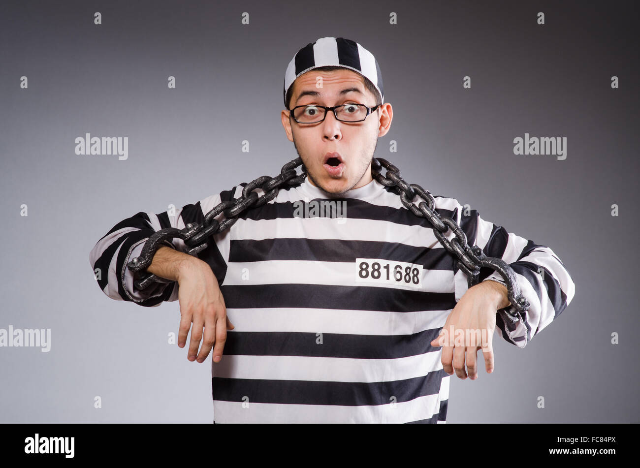 Young prisoner in chains against gray Stock Photo - Alamy