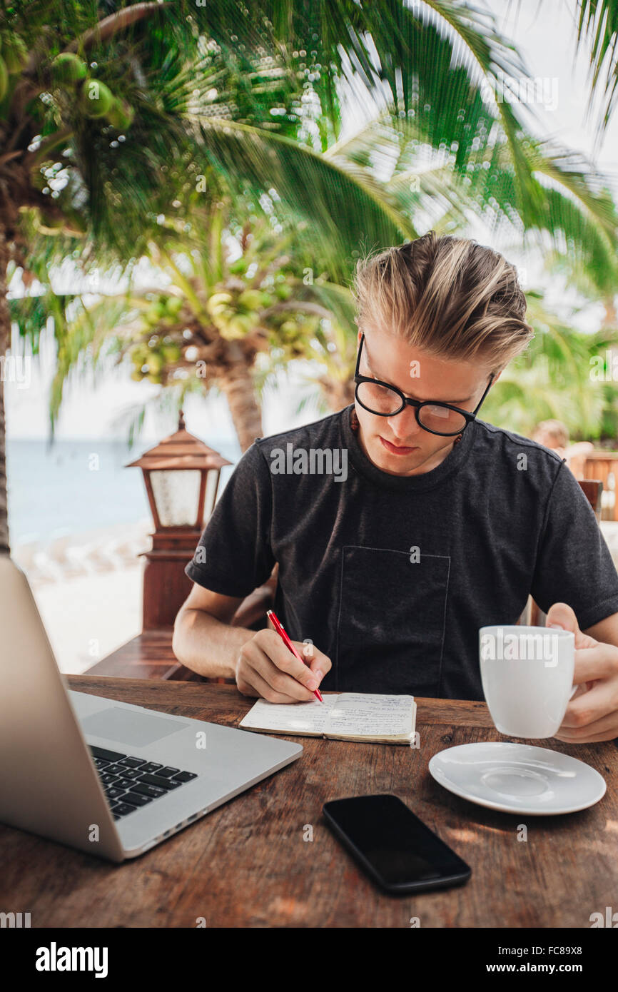 Caucasian man writing in cafe Stock Photo - Alamy