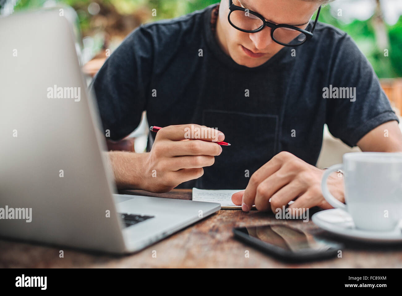 Man writing in cafe hi-res stock photography and images - Alamy