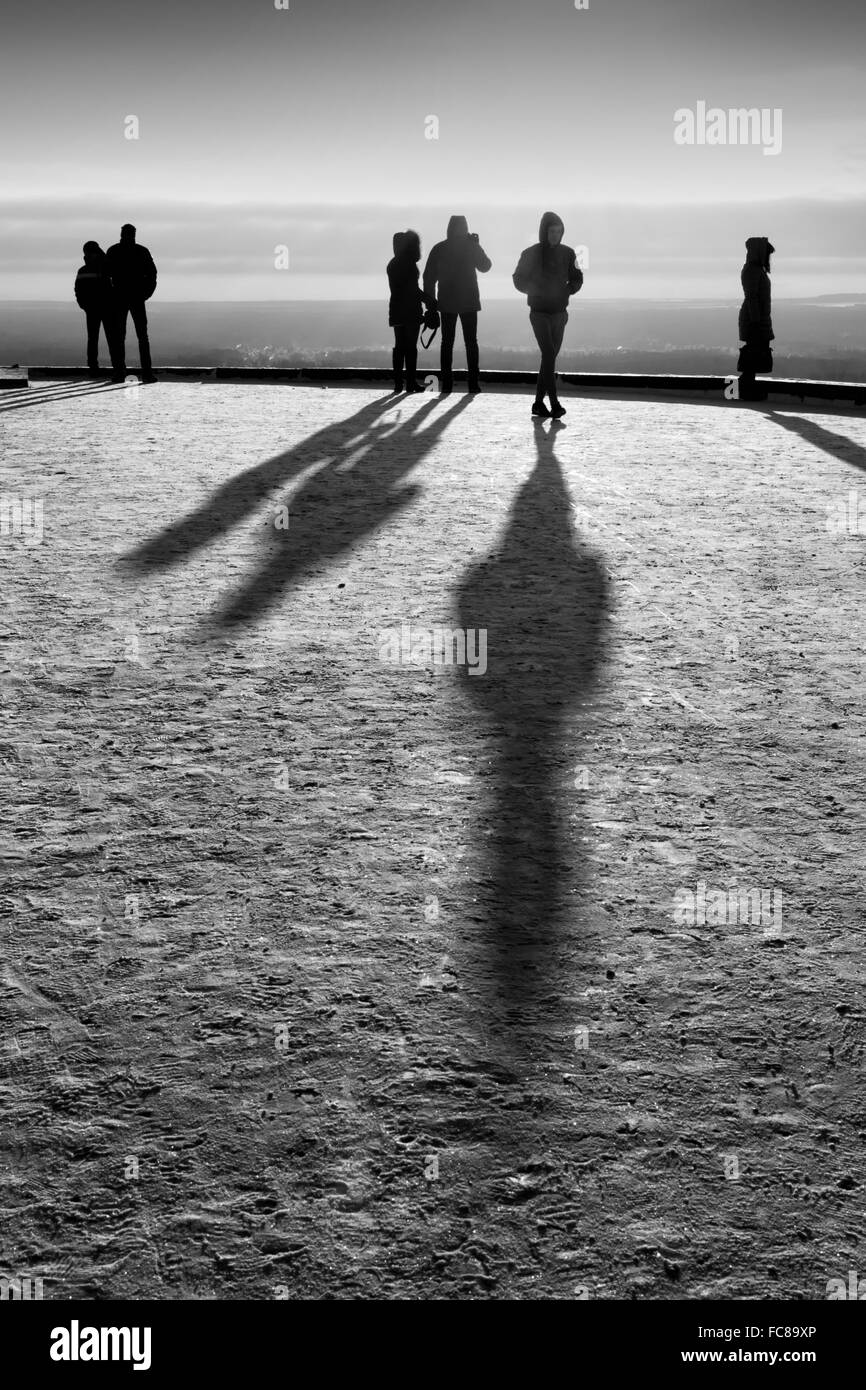 People standing and looking at the winter landscape that extends to the ...