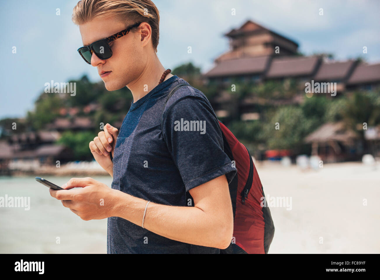 Caucasian man using cell phone on beach Stock Photo - Alamy