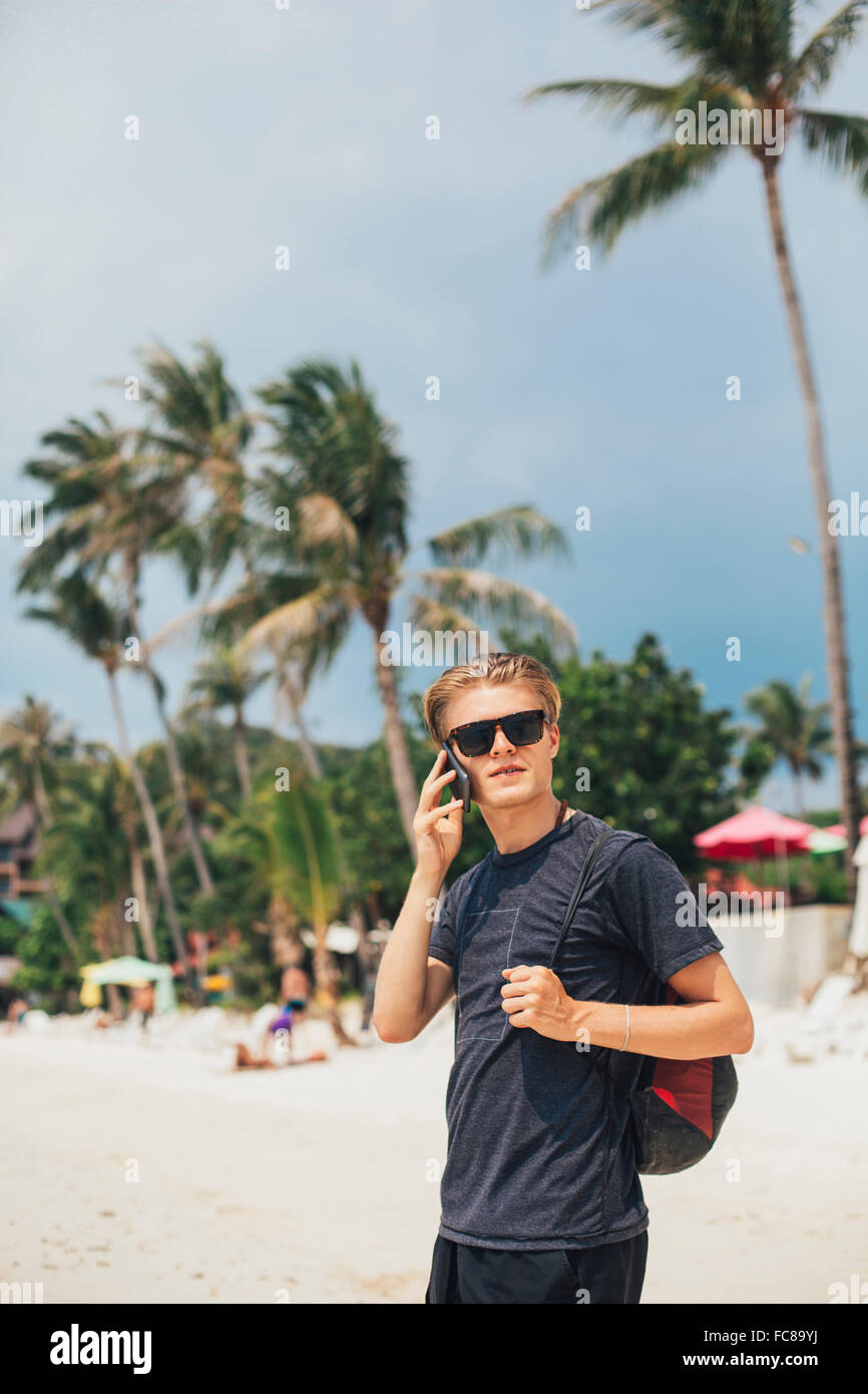 Caucasian man talking on cell phone on beach Stock Photo - Alamy
