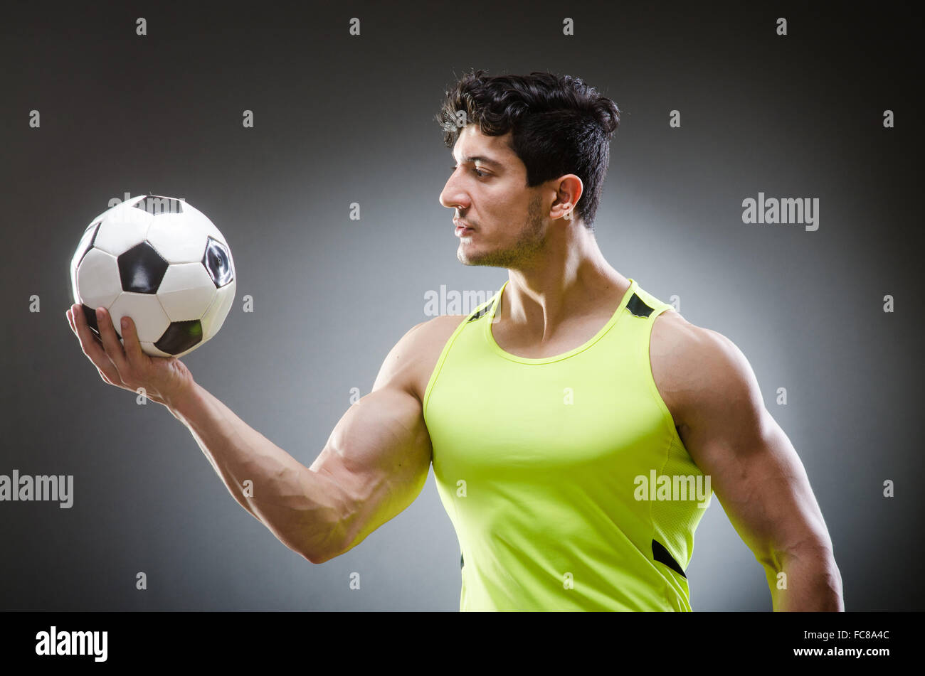 Muscular man with football ball Stock Photo - Alamy