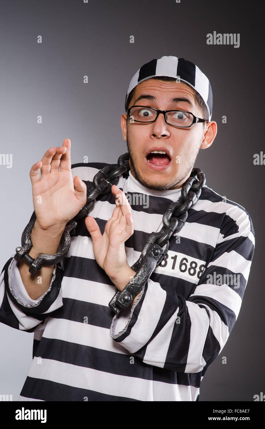 Young prisoner in chains against gray Stock Photo - Alamy