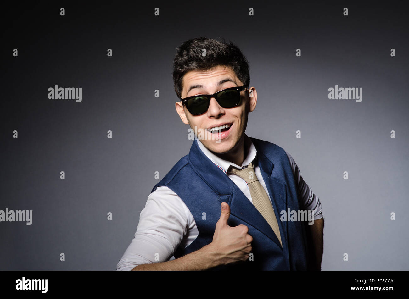 Young man in blue vest against gray Stock Photo - Alamy