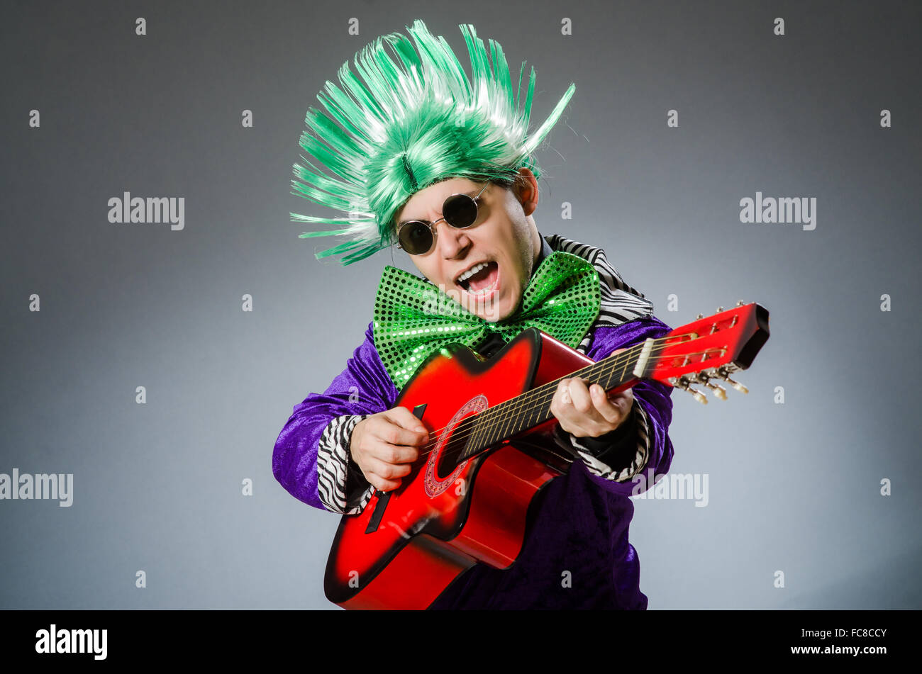Funny man playing guitar in musical concept Stock Photo - Alamy