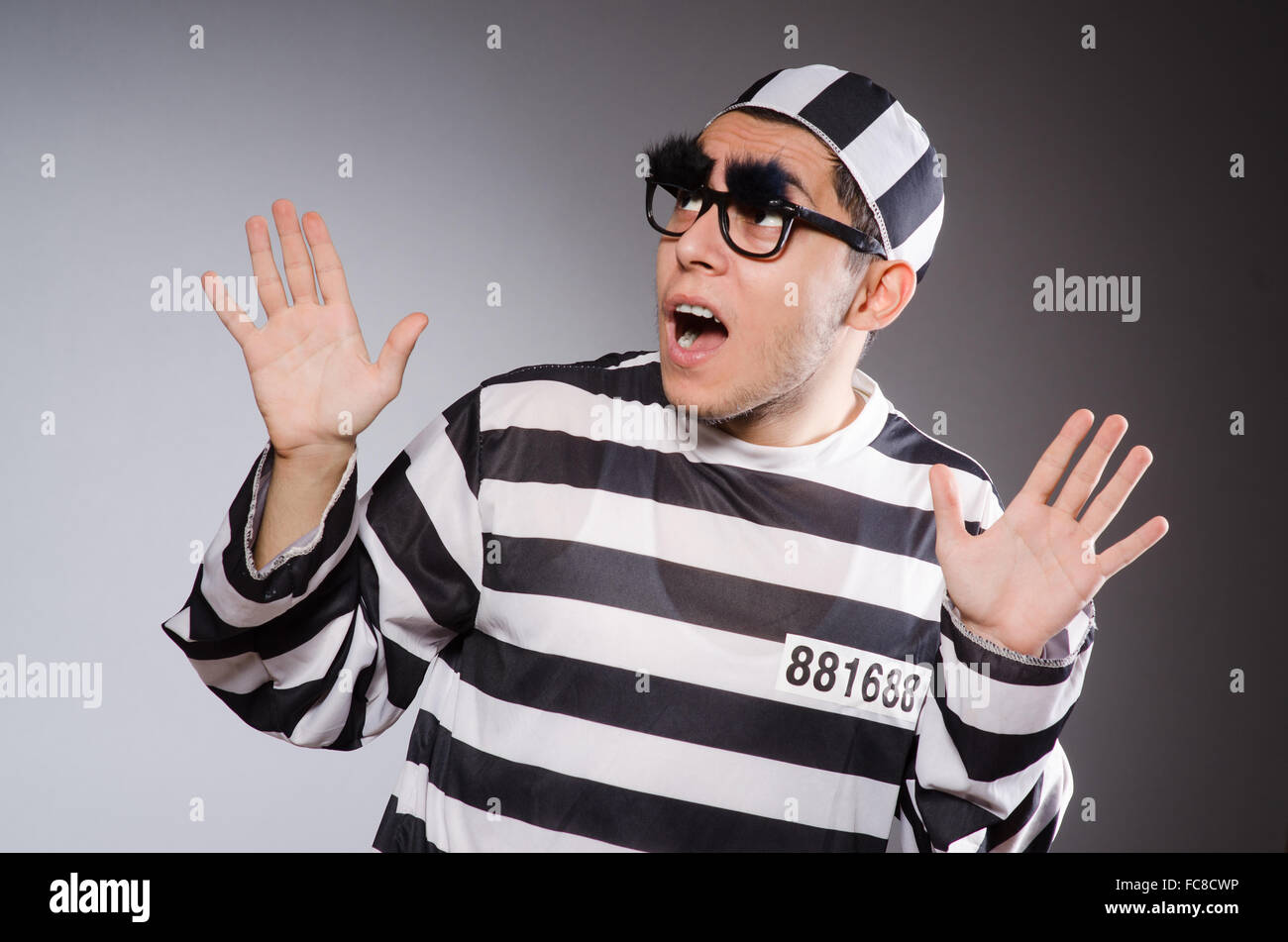 Funny prisoner with faked eyebrows in striped uniform Stock Photo - Alamy