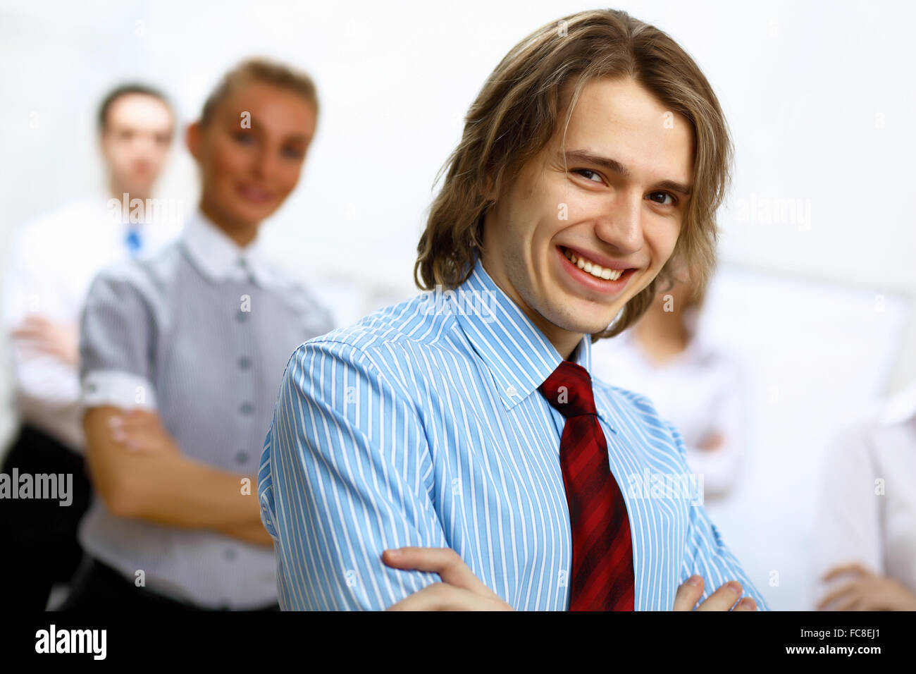 Young smiling happy businessman at work in office Stock Photo - Alamy