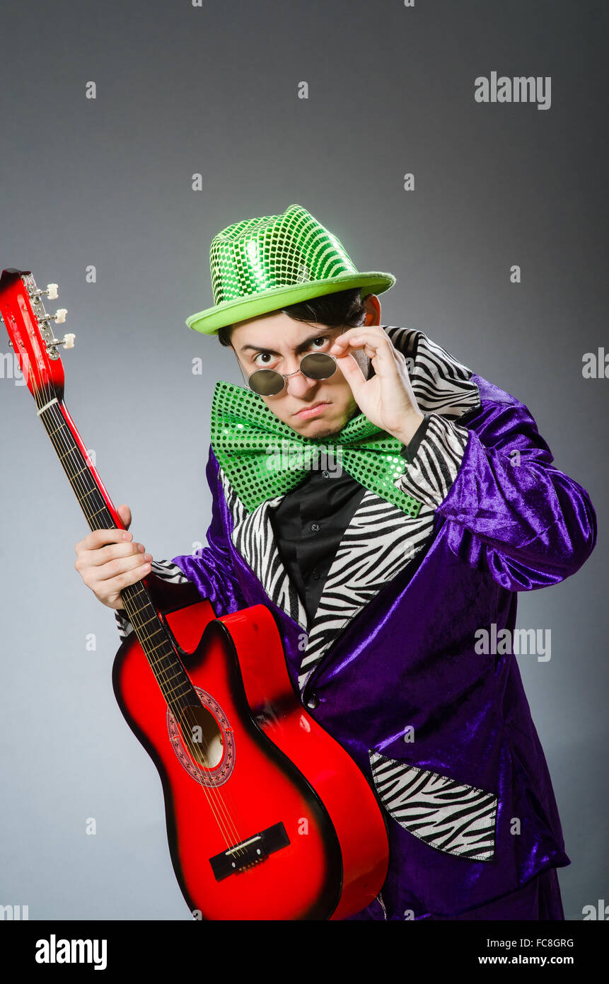 Funny man playing guitar in musical concept Stock Photo - Alamy