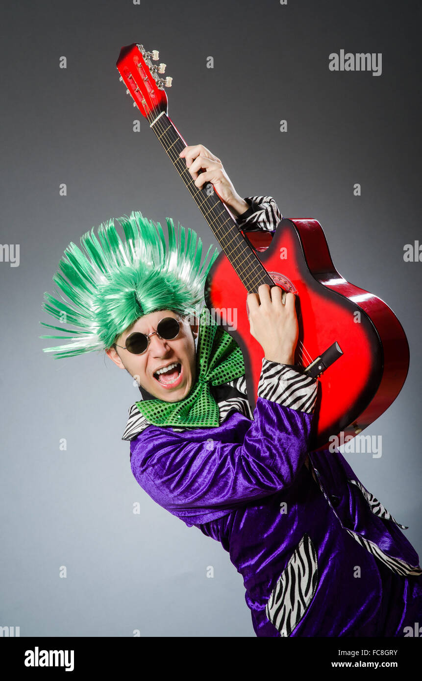 Funny man playing guitar in musical concept Stock Photo - Alamy