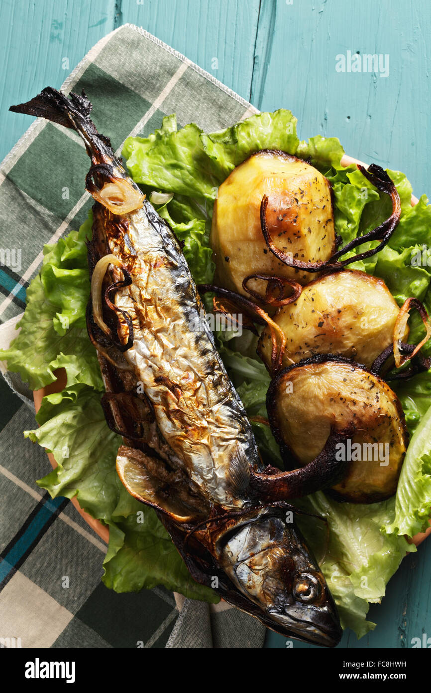 Baked fish and potatoes on plate above view Stock Photo - Alamy