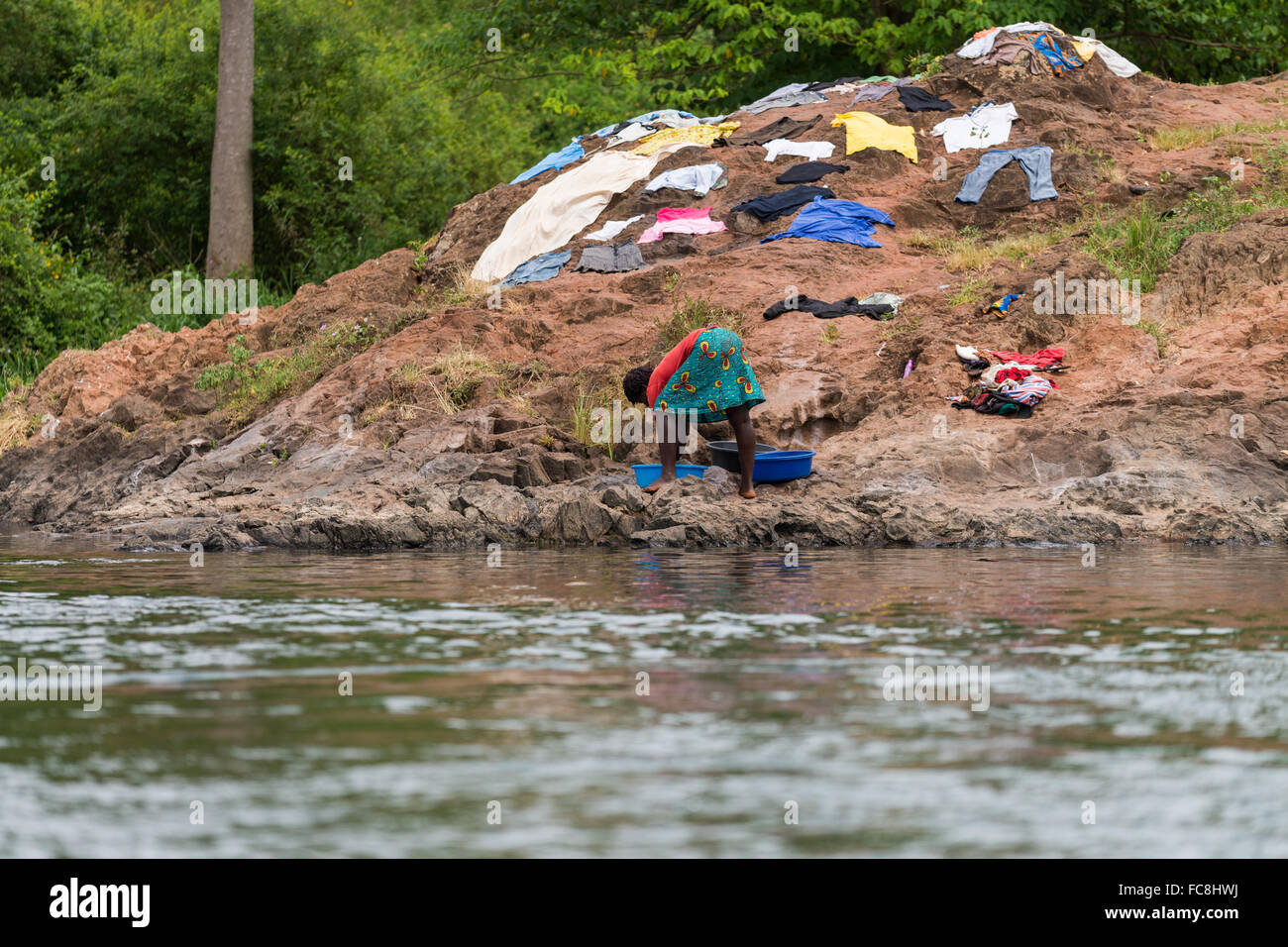 Local villagers washing and drying clothes by the river in Jinja ...