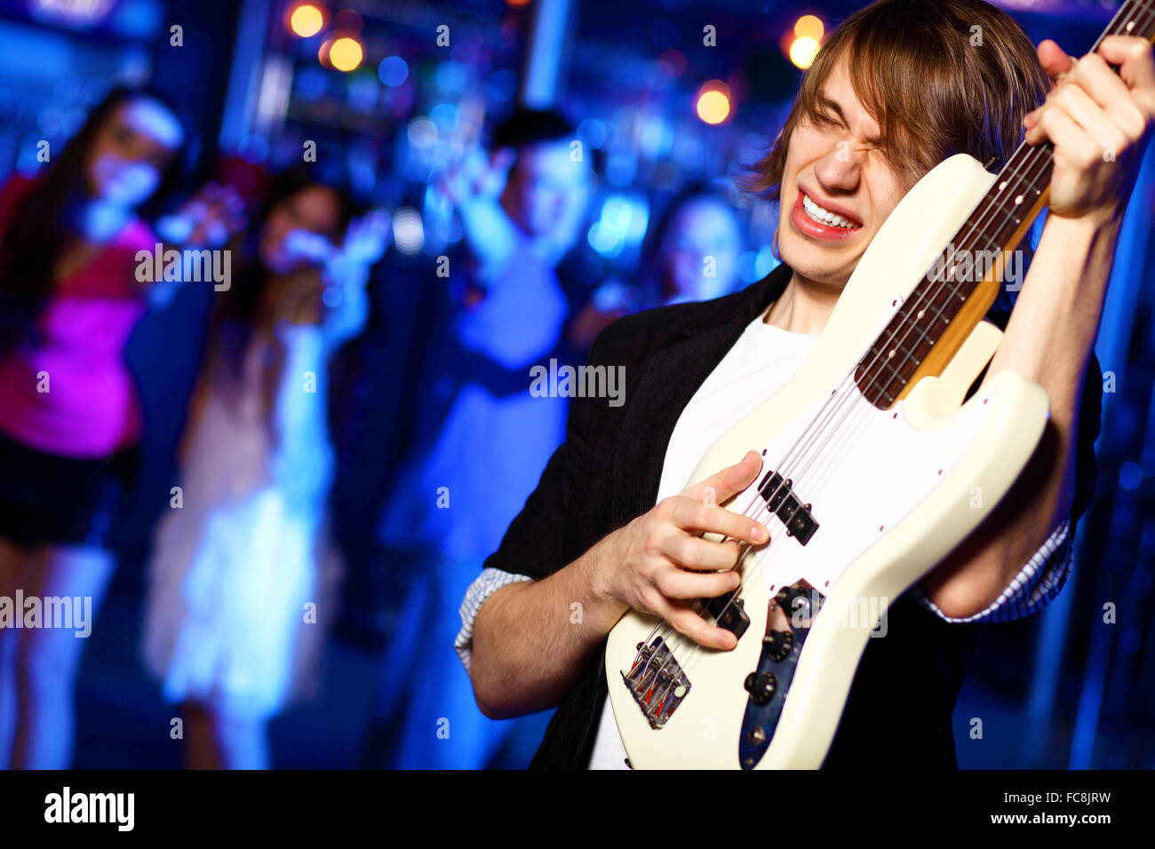Young guitar player with instrument performing in night club Stock ...