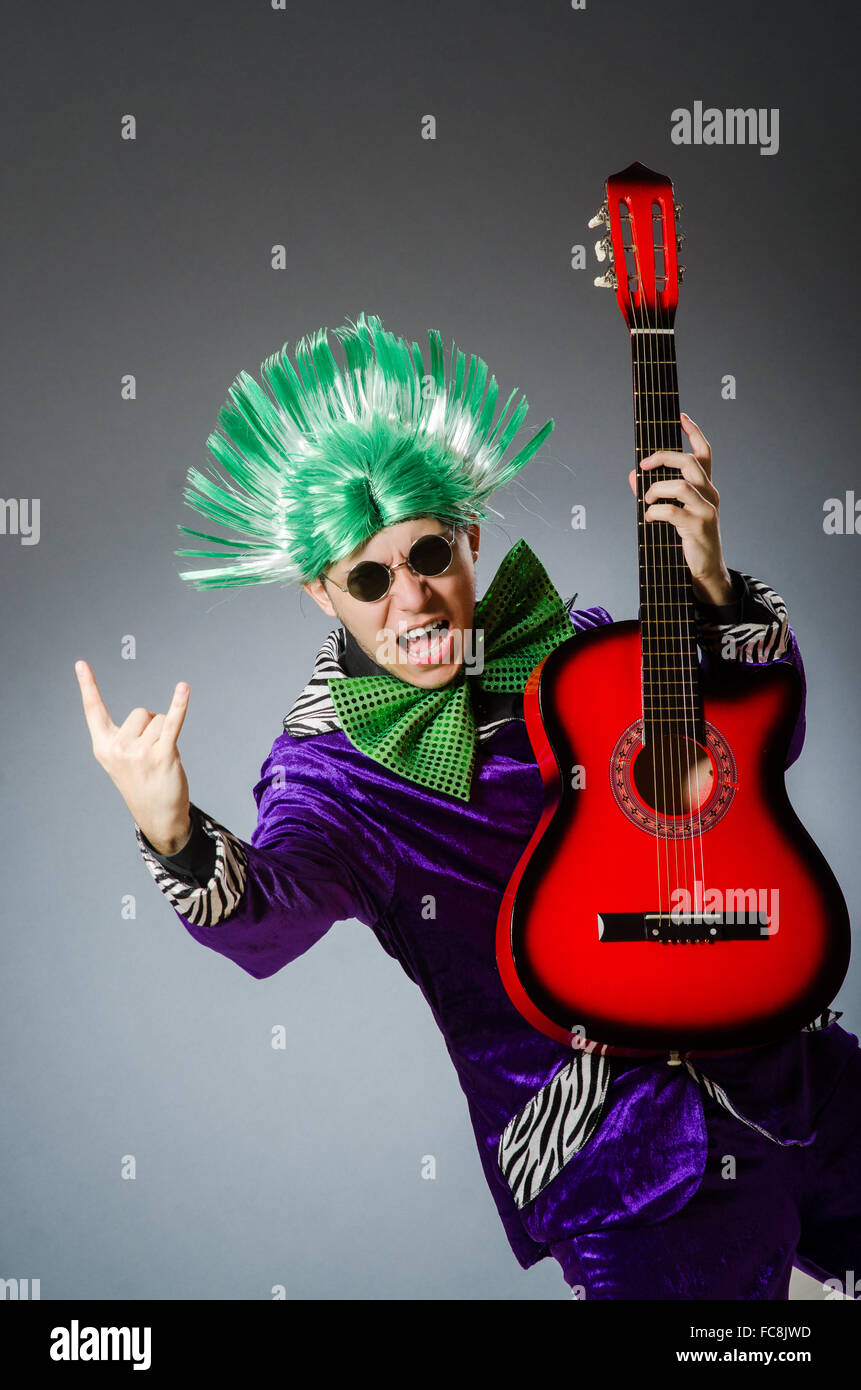 Funny man playing guitar in musical concept Stock Photo - Alamy