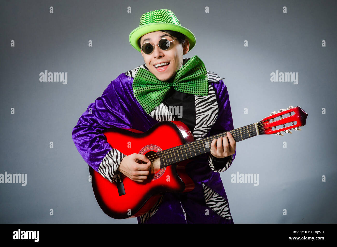 Funny man playing guitar in musical concept Stock Photo - Alamy