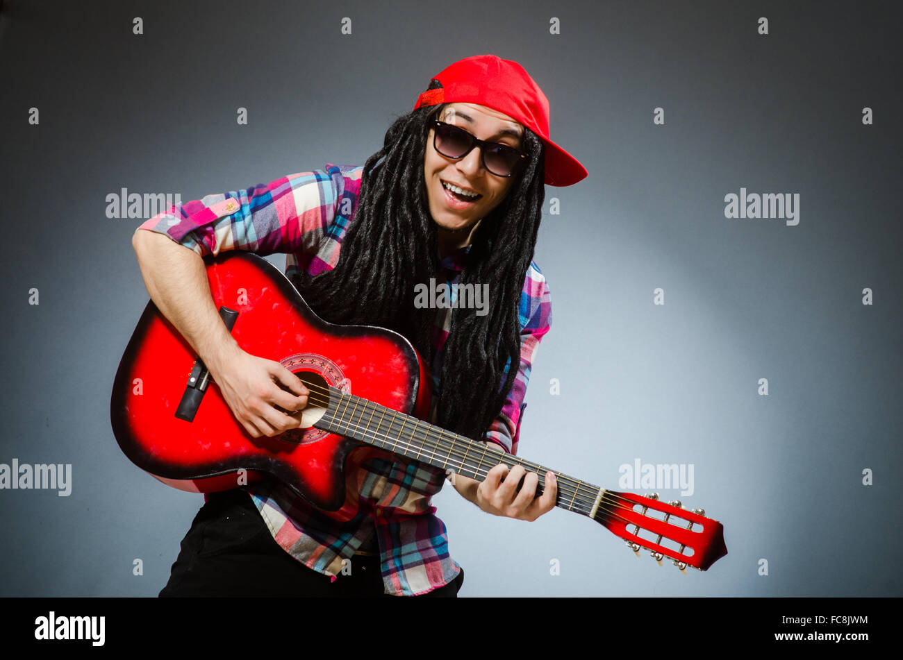 Funny man playing guitar in musical concept Stock Photo - Alamy