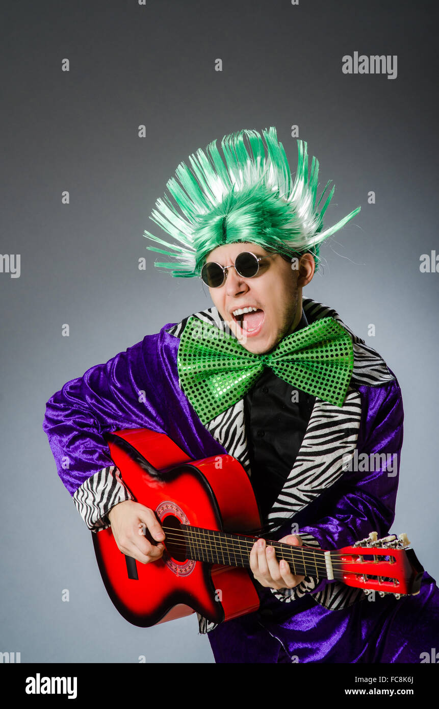 Funny man playing guitar in musical concept Stock Photo - Alamy