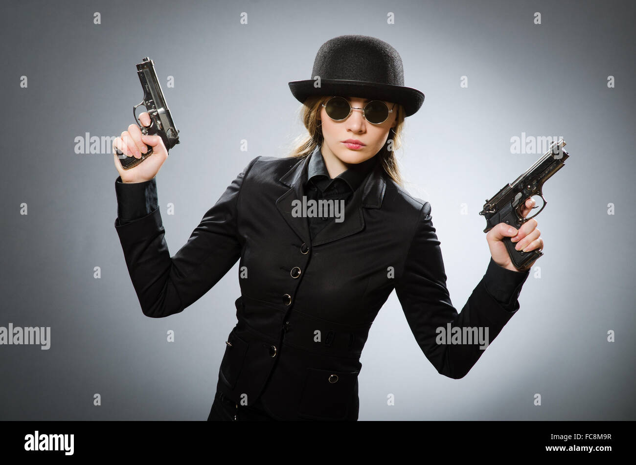 Female spy with weapon against gray Stock Photo - Alamy Female spy with weapon against gray Stock Photo - Alamy