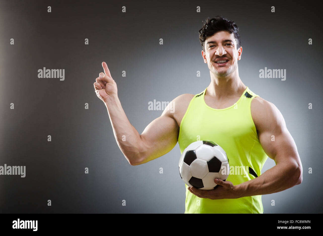Muscular man with football ball Stock Photo - Alamy