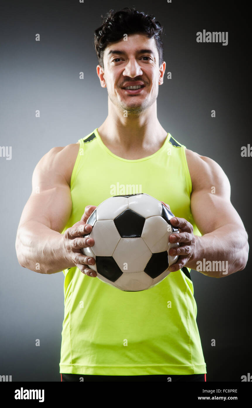 Muscular man with football ball Stock Photo - Alamy
