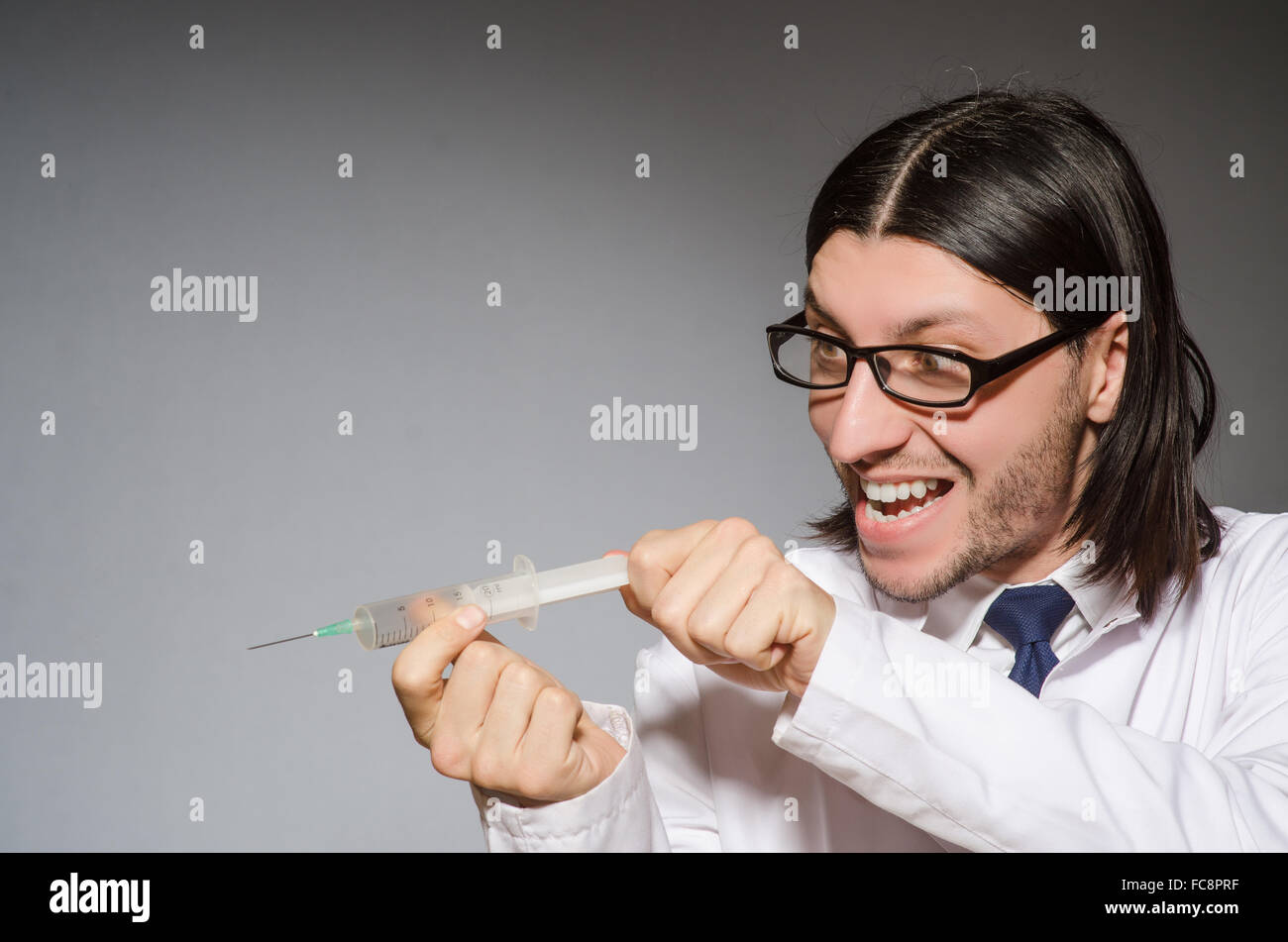 Male doctor holding syringe against gray Stock Photo - Alamy