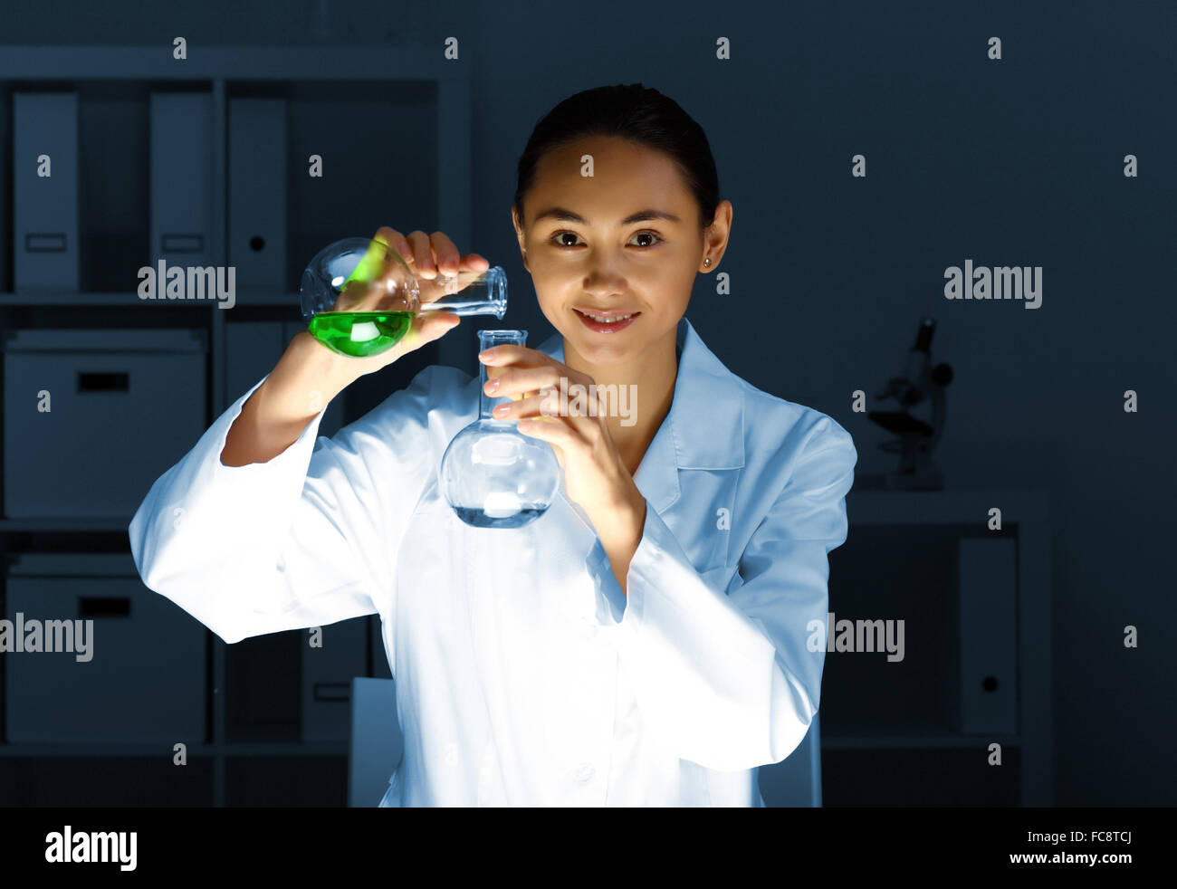 Young chemist in white uniform working in laboratory Stock Photo - Alamy