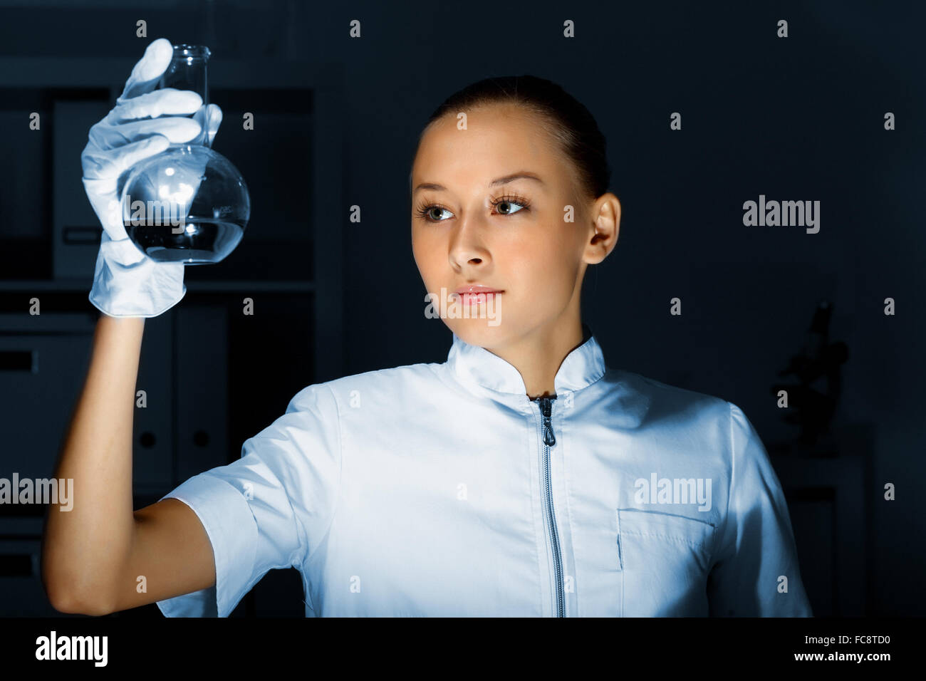 Young chemist in white uniform working in laboratory Stock Photo - Alamy