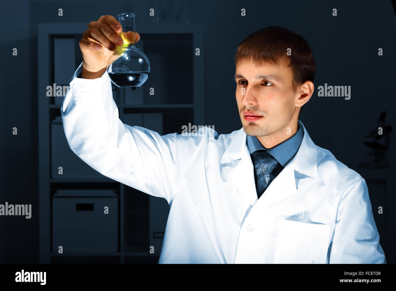 Young chemist in white uniform working in laboratory Stock Photo - Alamy