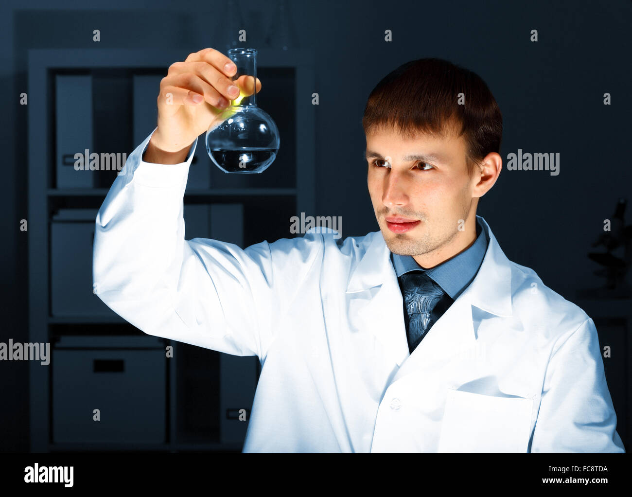 Young chemist in white uniform working in laboratory Stock Photo - Alamy