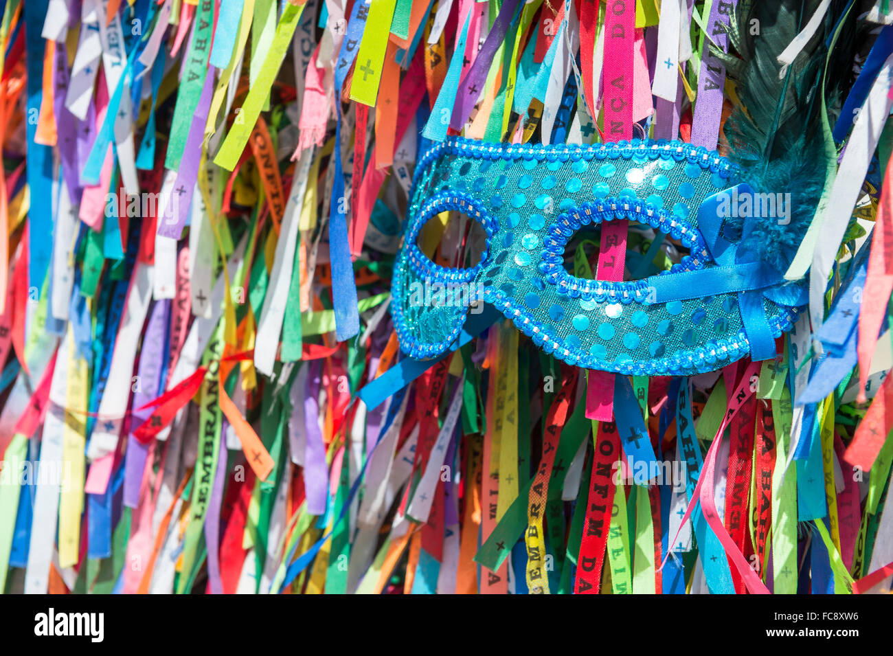 Blue sequined carnival mask in a background of Brazilian wish ribbons ...