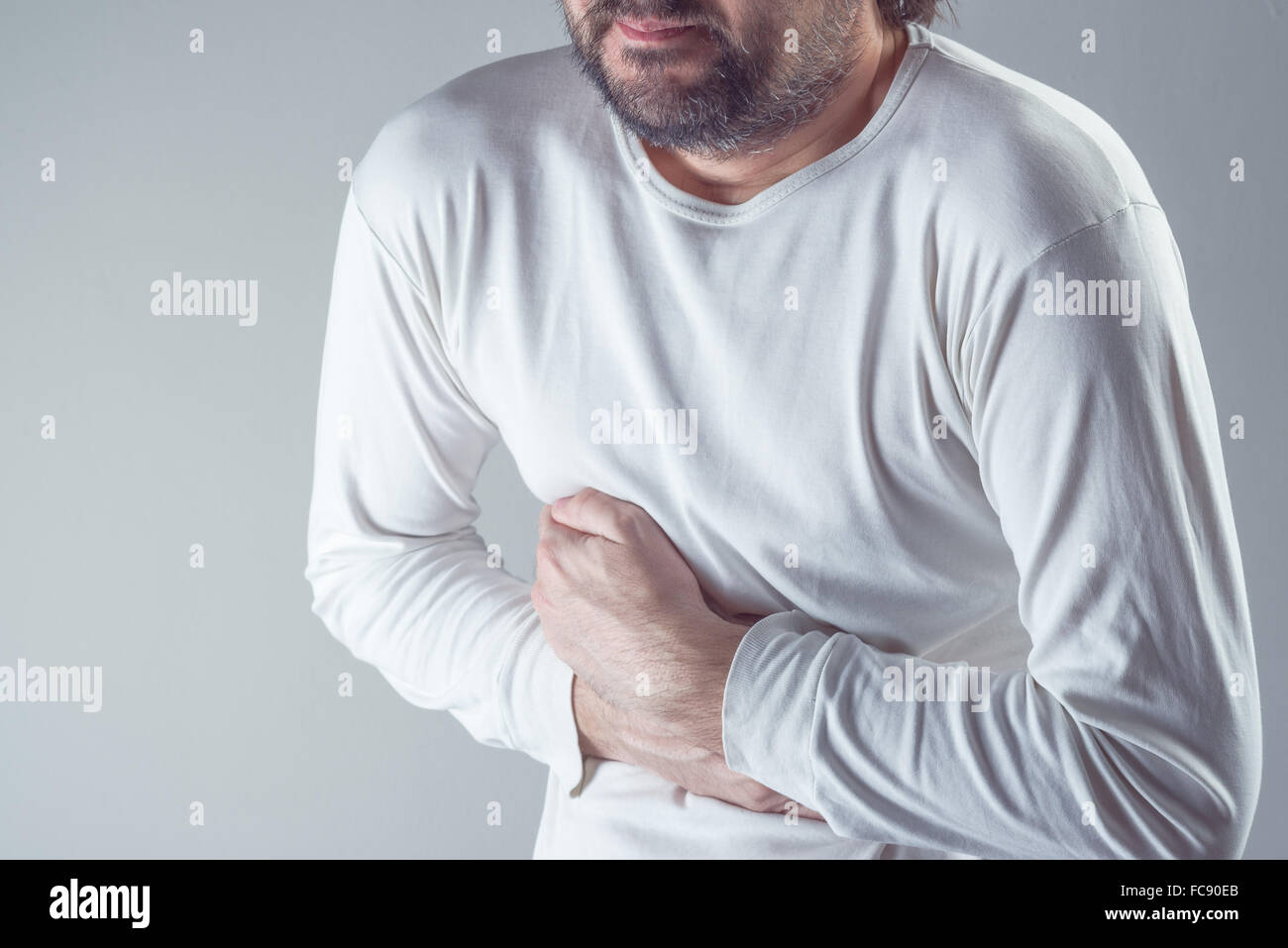 Severe abdominal pain, man suffering from stomach ache, holding his ...