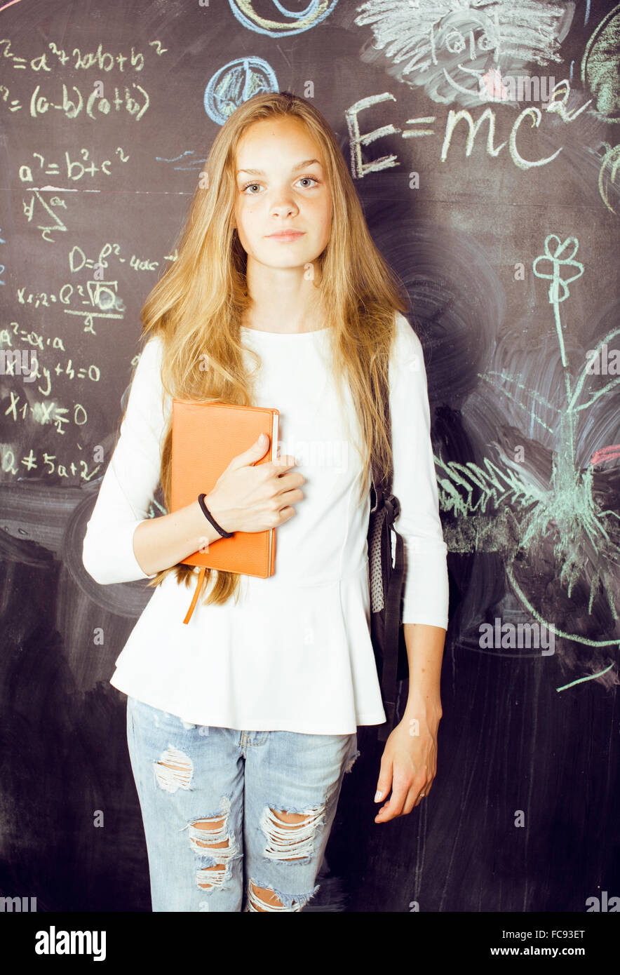young pretty girl student in classroom at blackboard doing homework ...