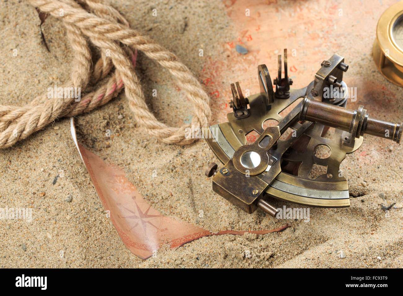 set of nautical instruments, lying on the sand and old map. concept ...