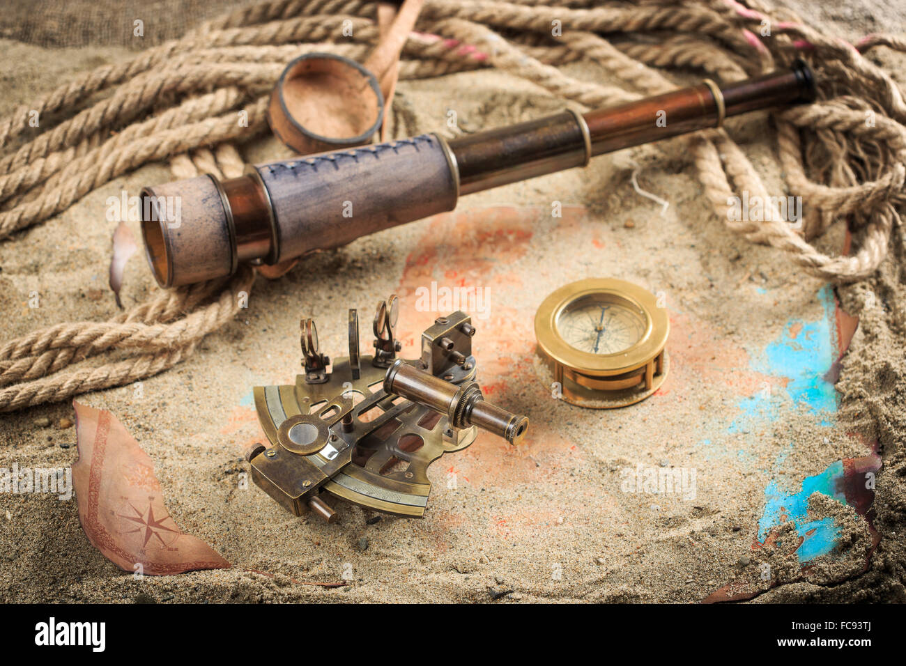 set of nautical instruments, lying on the sand and old map. concept ...