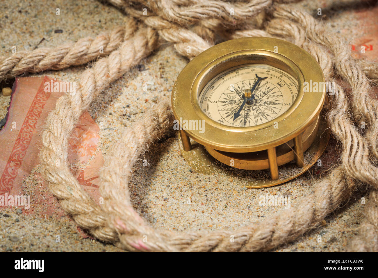 set of nautical instruments, lying on the sand and old map. concept ...