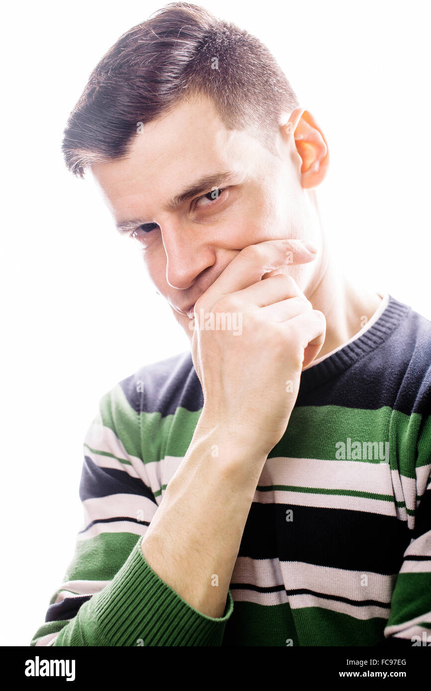 Portrait of a smart serious young man standing against white background ...