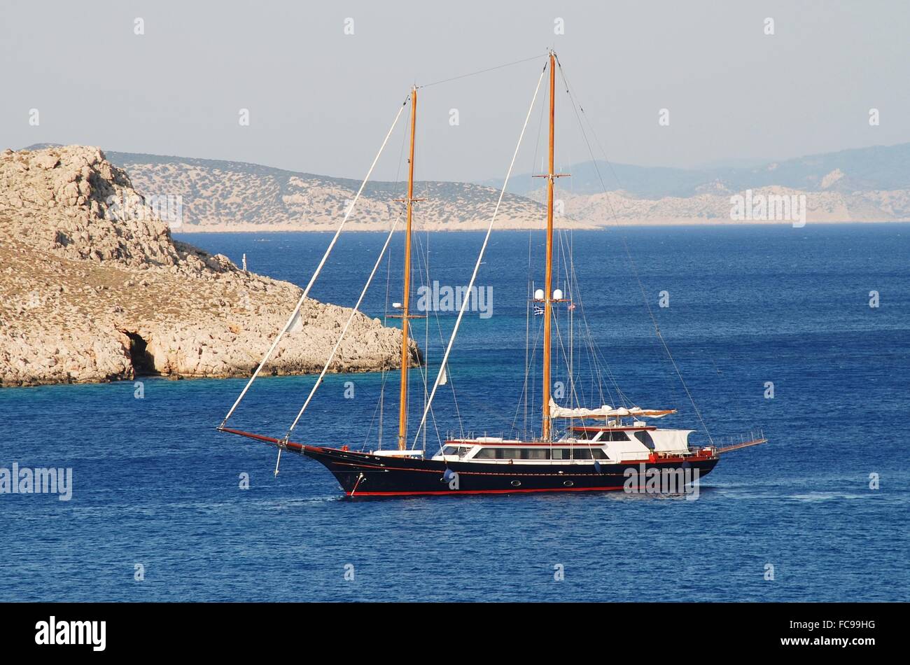 A twin masted yacht entering Emborio harbour on the Greek island of ...