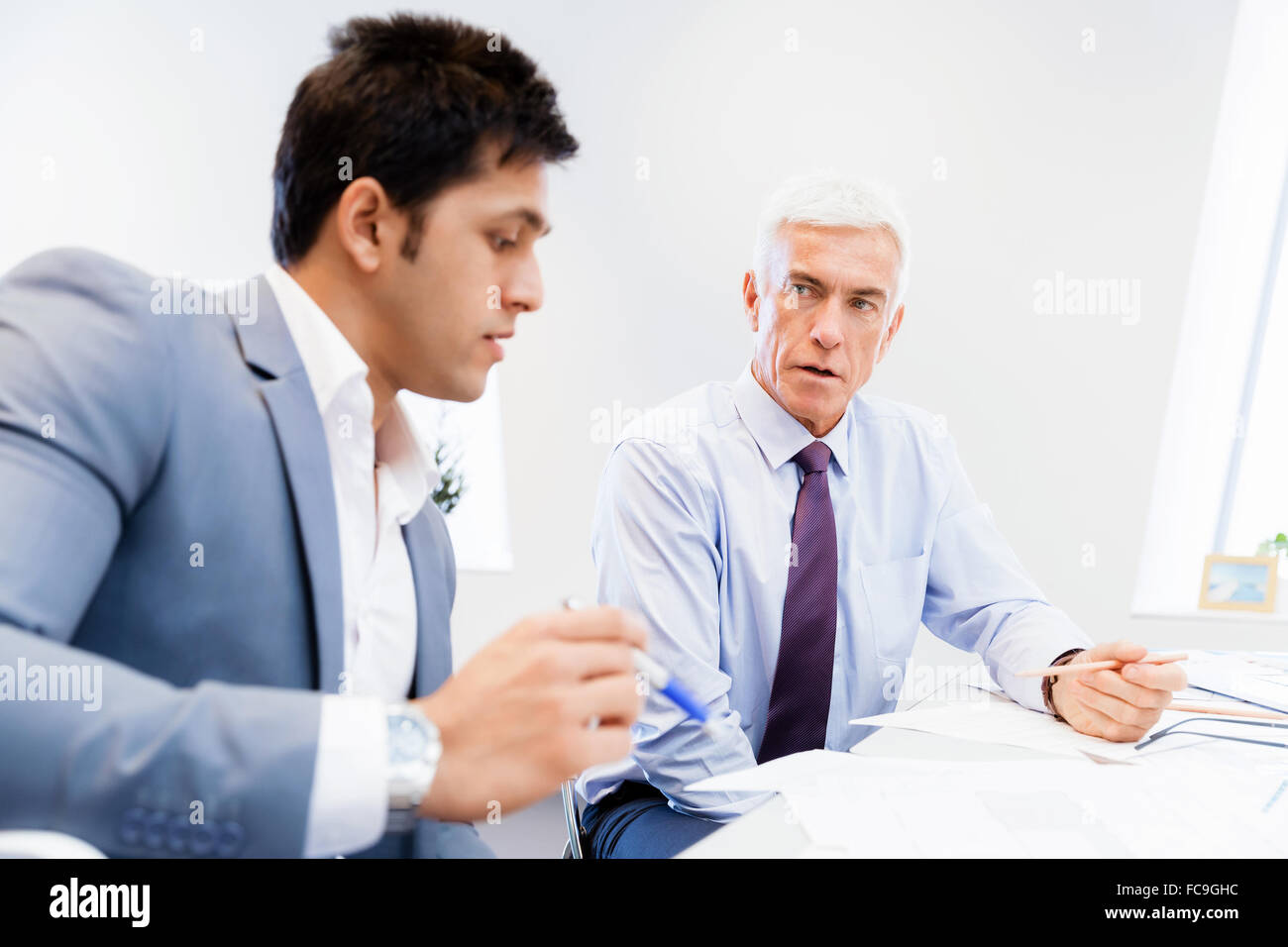 Two businessman in office having discussion Stock Photo - Alamy