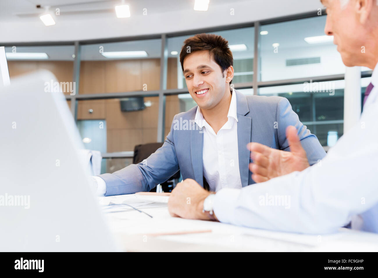 Two businessman in office having discussion Stock Photo - Alamy