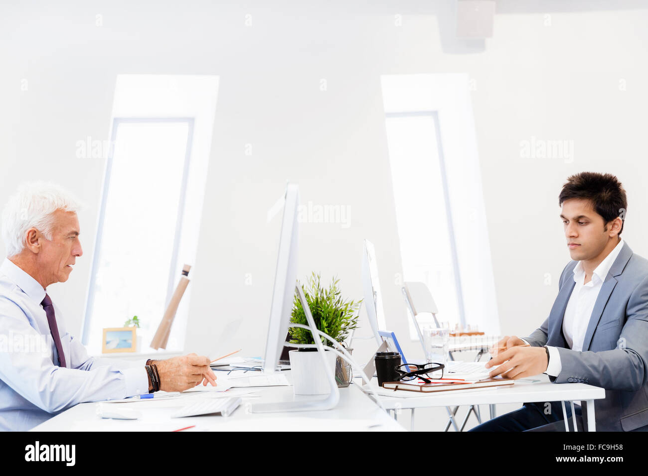 Two businessmen in fornt of their computers in office Stock Photo - Alamy
