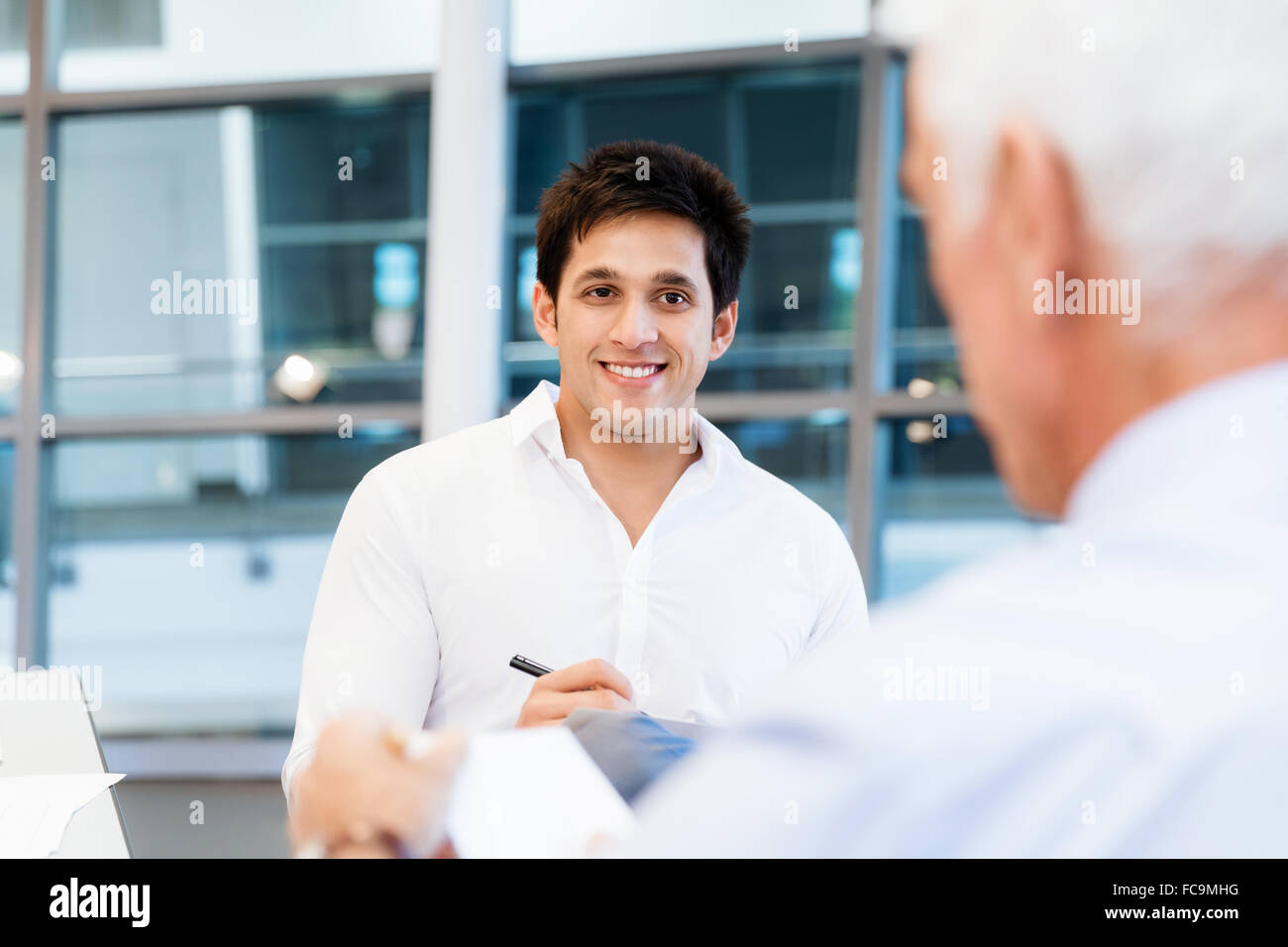 Two businessmen during interview in office Stock Photo - Alamy