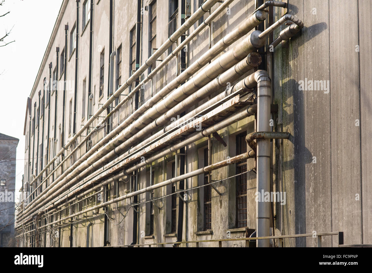Old pipes on the wall outside of an old abandoned factory Stock Photo ...