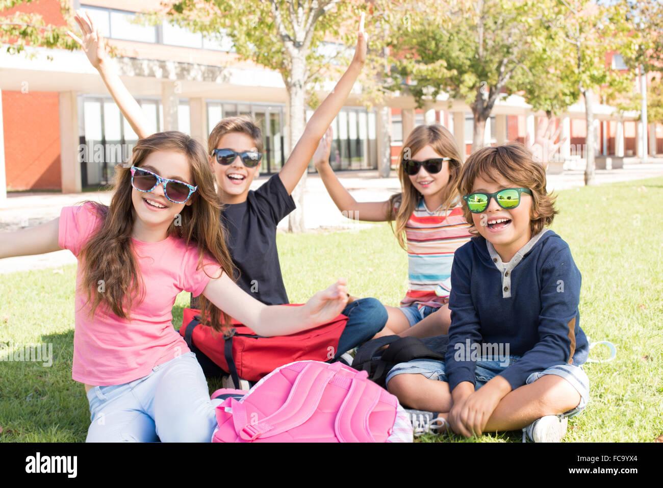 Group of little students sitting on the grass at school Stock Photo - Alamy