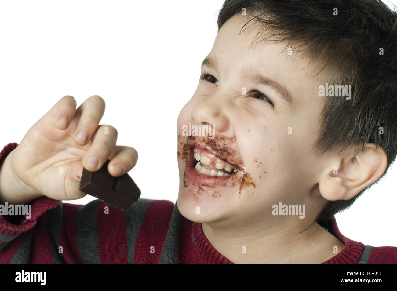 Smiling little boy eating chocolate Stock Photo - Alamy