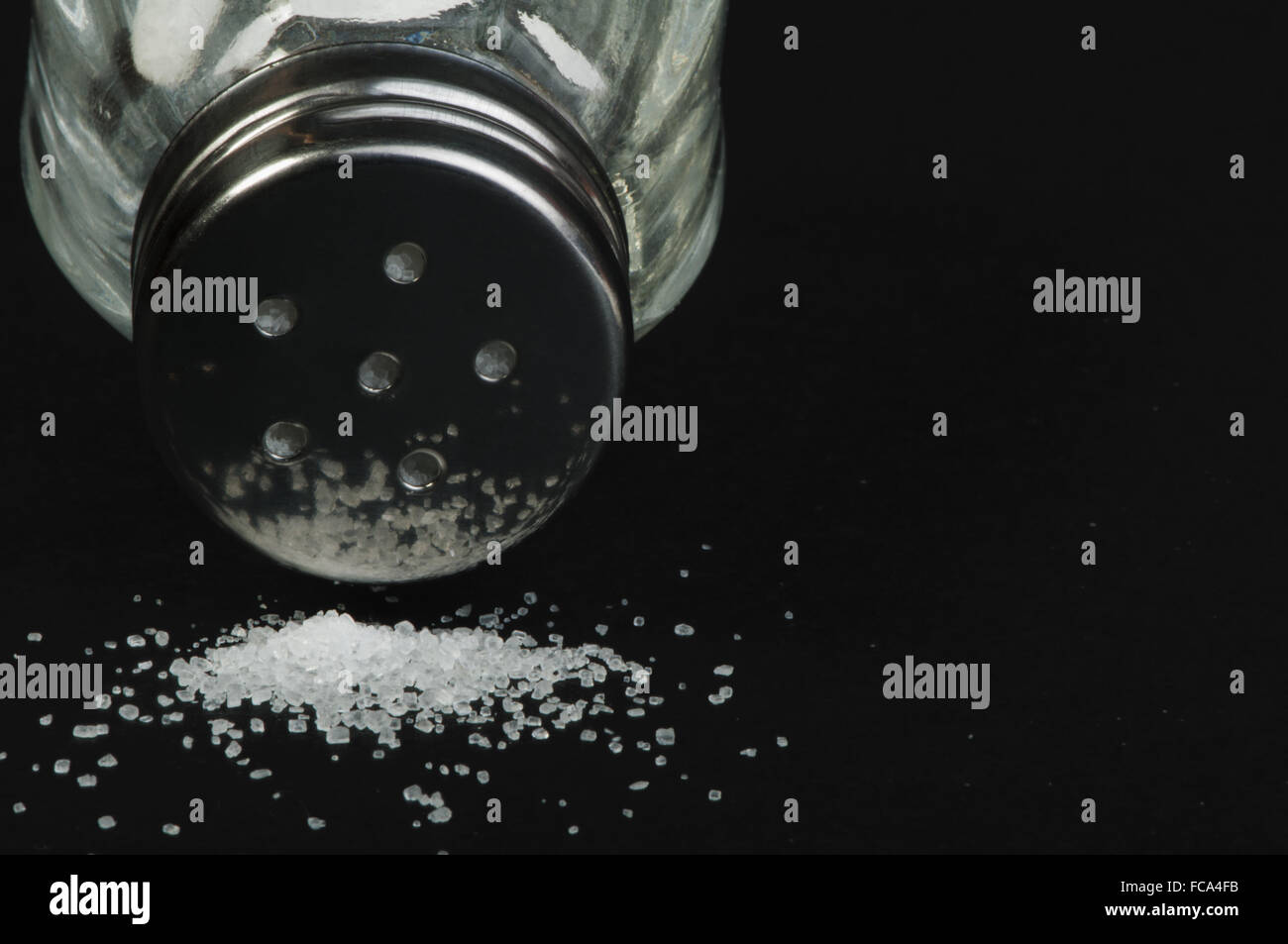 Salt on black background Stock Photo - Alamy