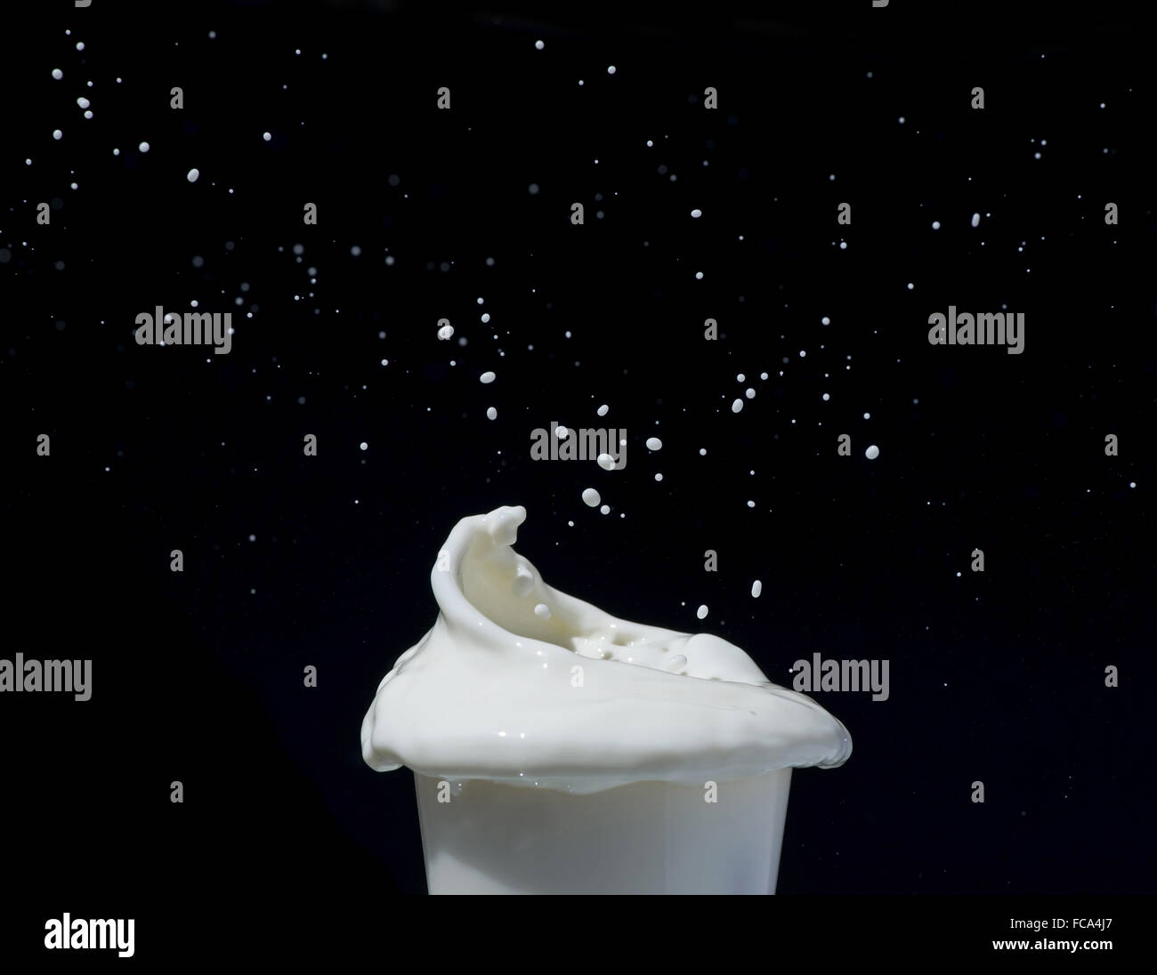 Splashing milk black isolated Stock Photo - Alamy