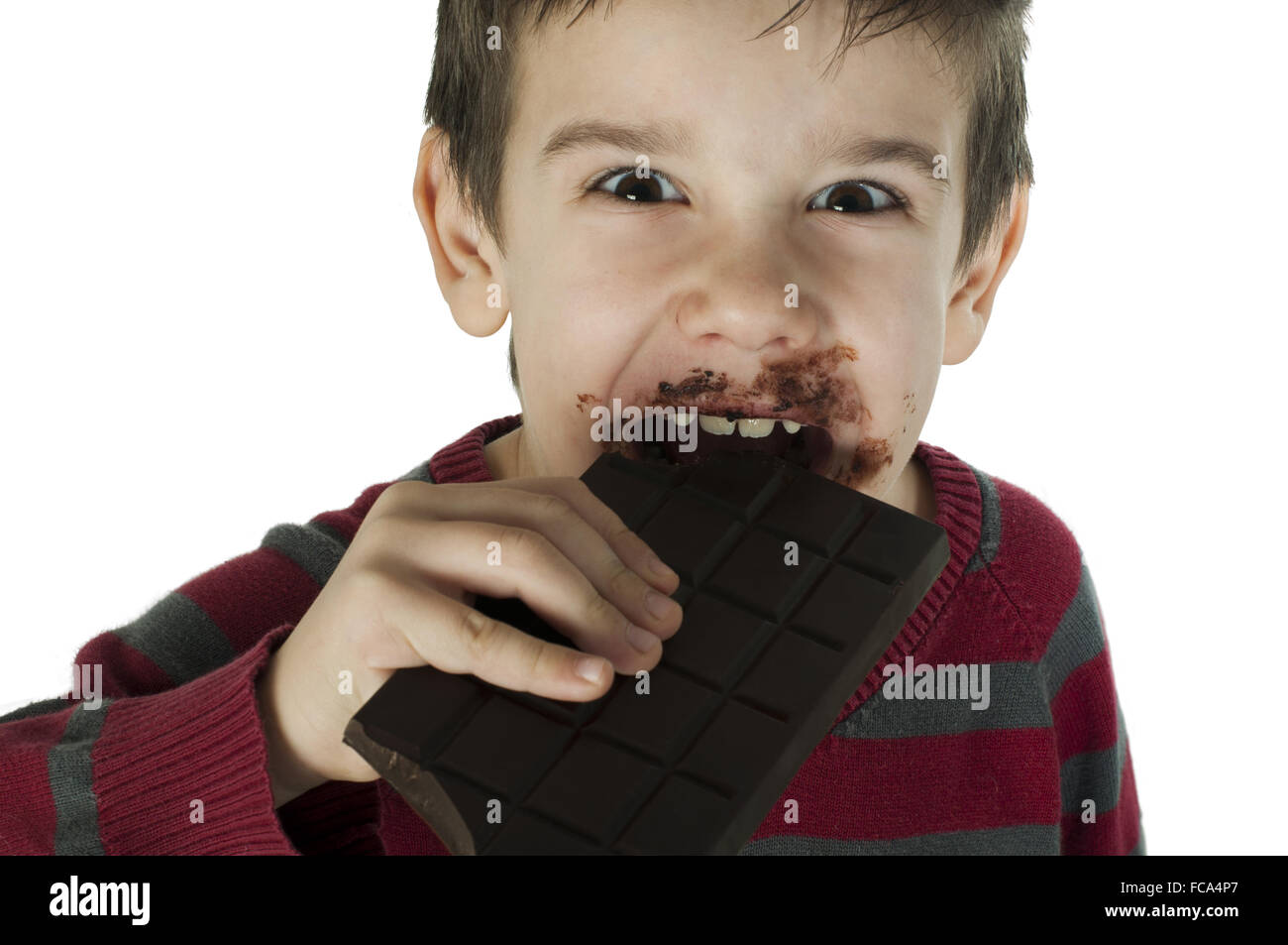 Smiling little boy eating chocolate Stock Photo - Alamy