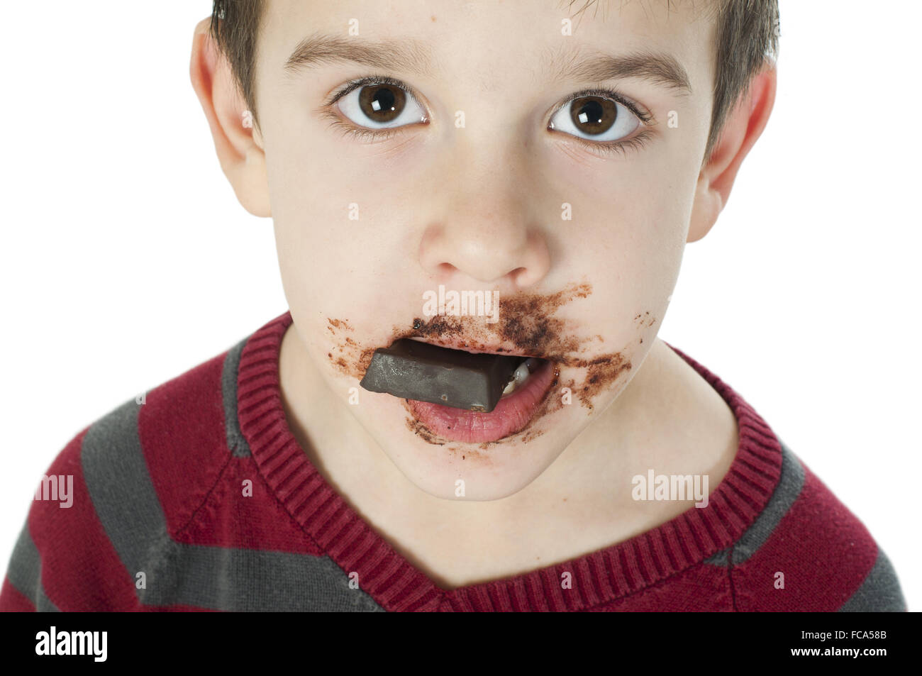 Smiling little boy eating chocolate Stock Photo - Alamy