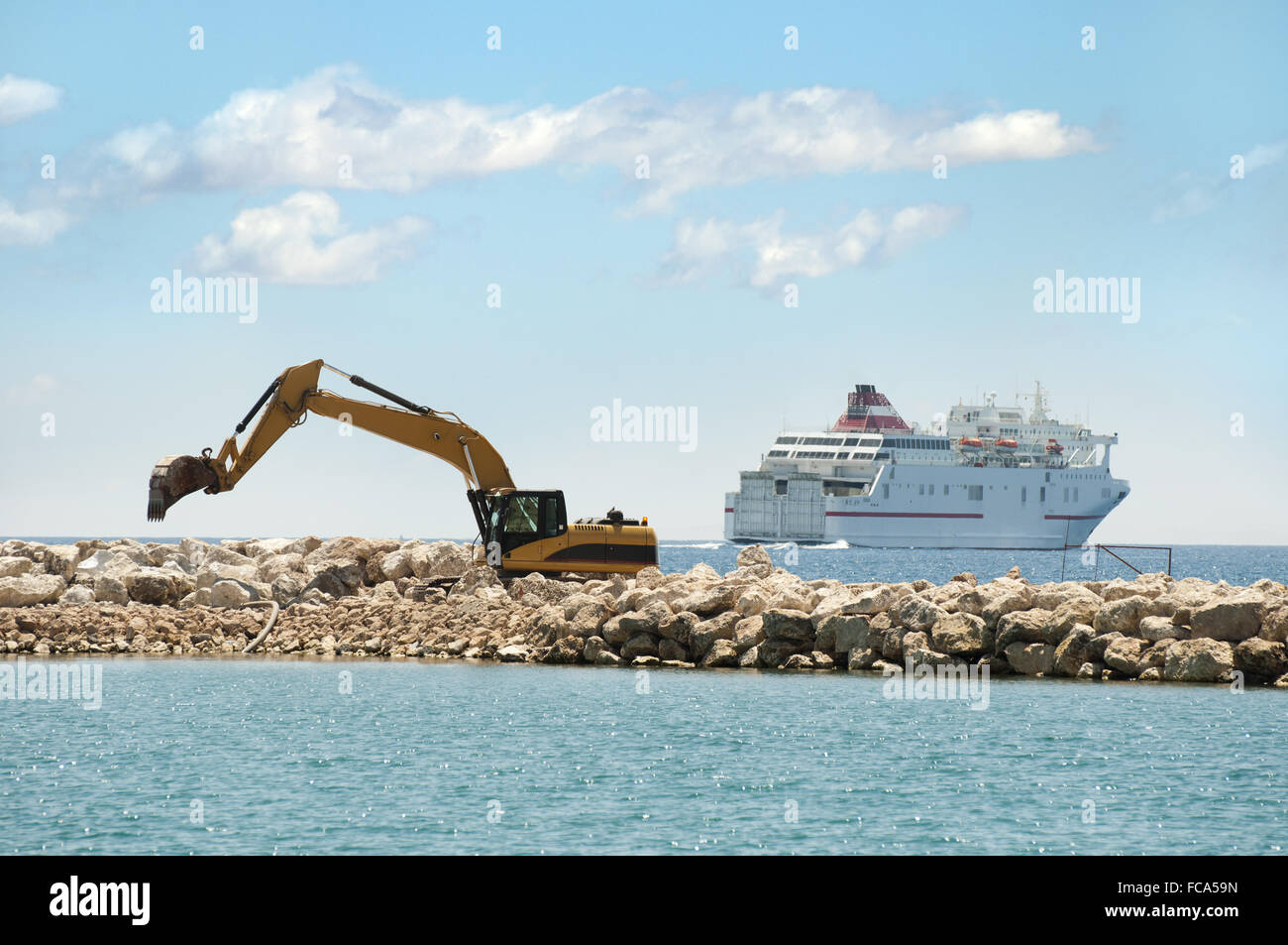 Building a dike. Excavator put stones Stock Photo - Alamy