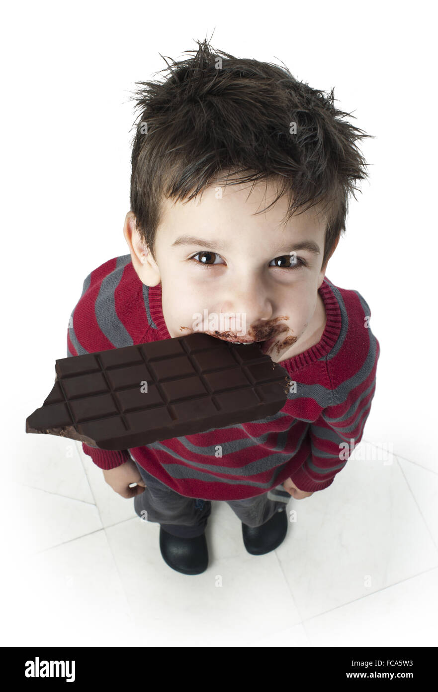 Smiling little boy eating chocolate Stock Photo - Alamy